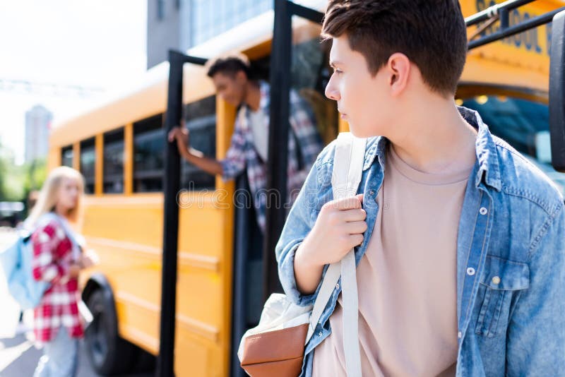 Teen Schoolboy Walking in Front of School Bus and Turning Back Stock ...