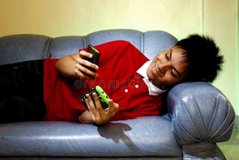 Teen Using Smartphone Lying Down Couch Smiling Stock Photos - Free ...