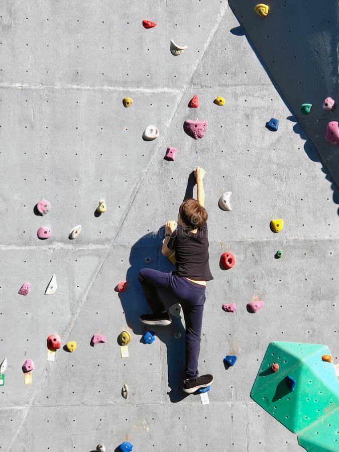 A Teenage Boy is Crawling on a Rock Climbing Wall in Training Stock ...