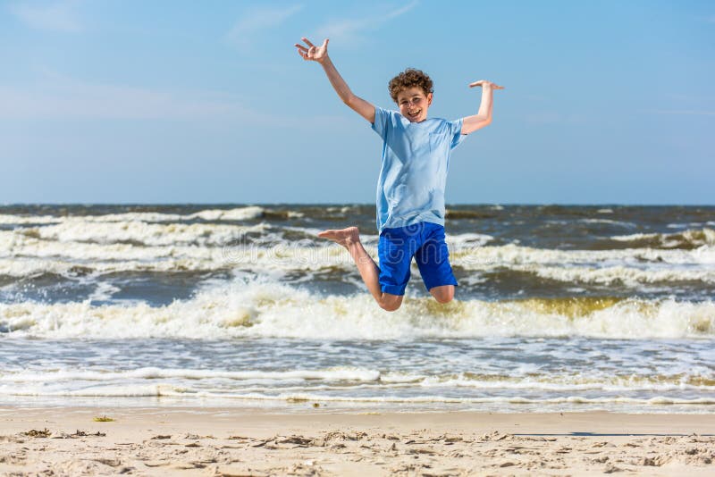 Teenage Boy Jumping, Running on Beach Stock Photo - Image of people ...