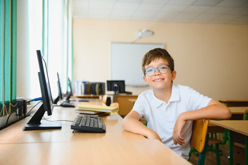 Teenage Boy Smiling while Using Computer at Desk in Classroom Stock ...