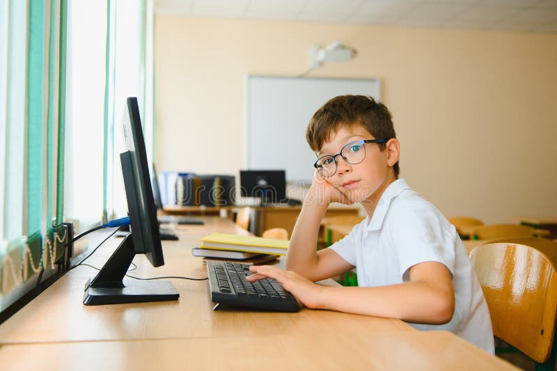 Teenage Boy Smiling while Using Computer at Desk in Classroom Stock ...