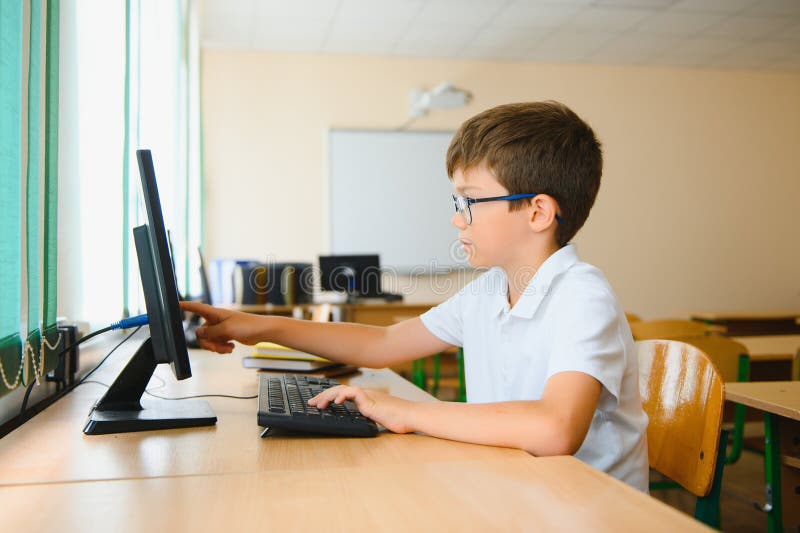 Teenage Boy Smiling while Using Computer at Desk in Classroom Stock ...