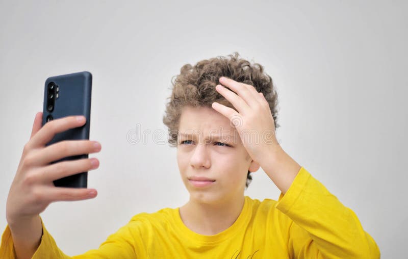 Teenage Boy Squeezes Acne while Looking at Phone. the Problem of ...