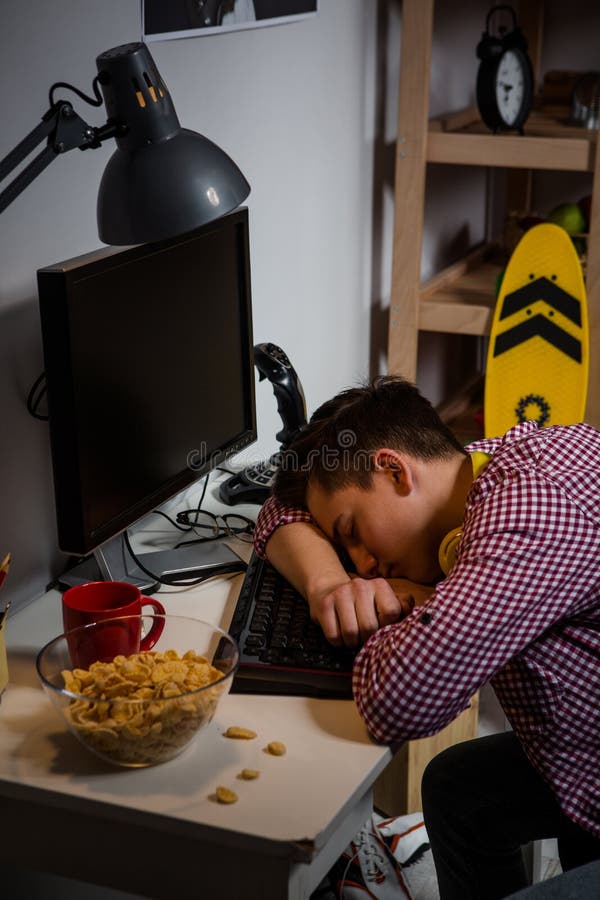 Teenage Boy Tired Falling Asleep at Computer Table. Stock Image - Image ...