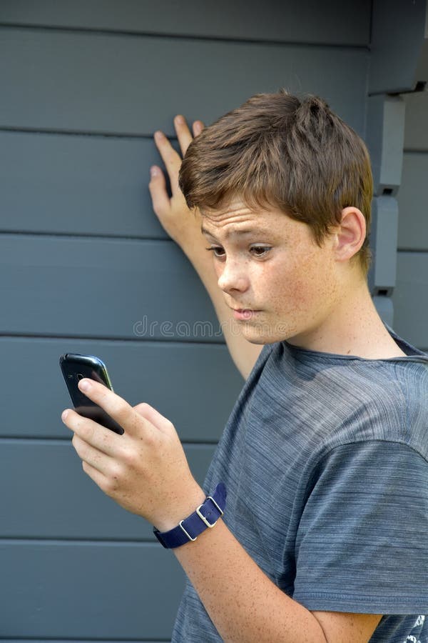 Teenage Boy Using Cellphone, he Gets Bad News Stock Photo - Image of ...