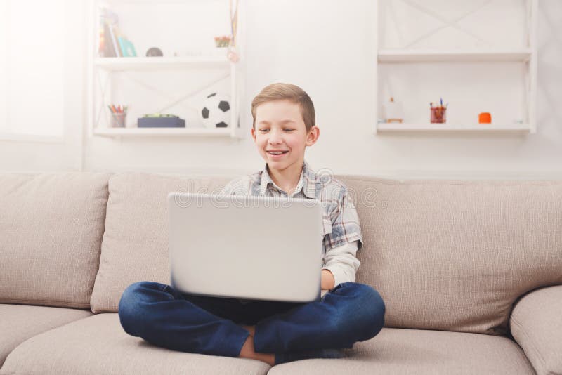 Teenage Boy Using Laptop on Couch at Home Stock Image - Image of ...