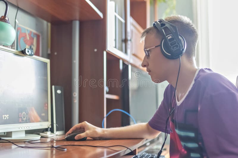 A Teenage Boy, a Young Man Playing Video Games on a Computer, Using ...