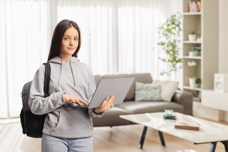 Teenage Female Student with a Backpack Browsing on a Laptop Computer ...