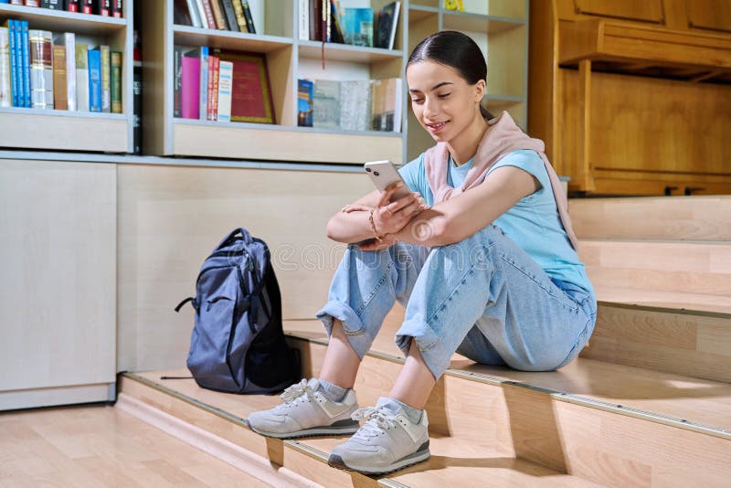 Teenage Female Student Using Smartphone Inside High School Library ...
