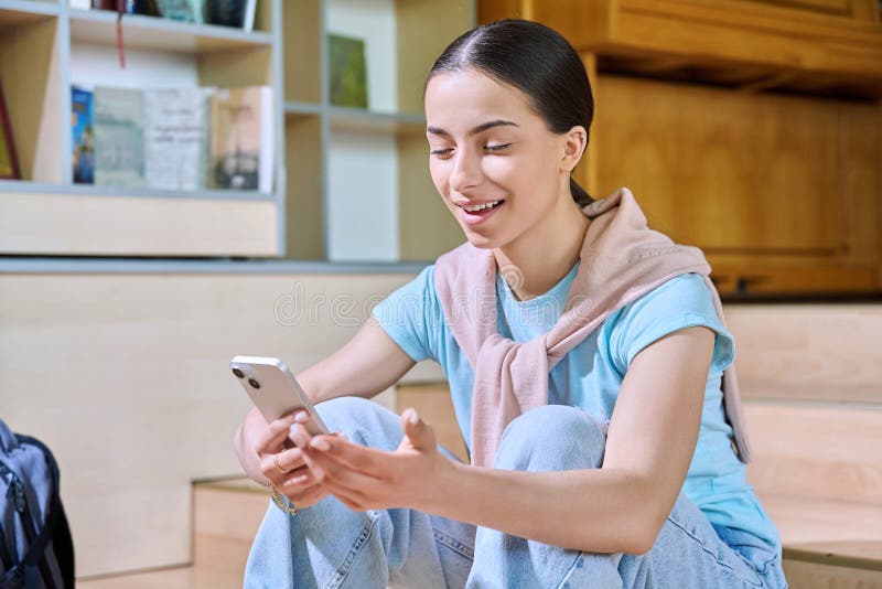 Teenage Female Student Using Smartphone, Inside High School Building ...