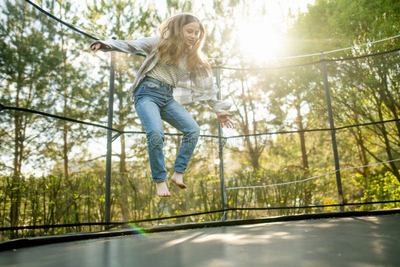 Teenage Girl Jumping on a Trampoline in a Backyard. Sports and ... Teenage Girl Jumping on a Trampoline in a Backyard. Sports and ...