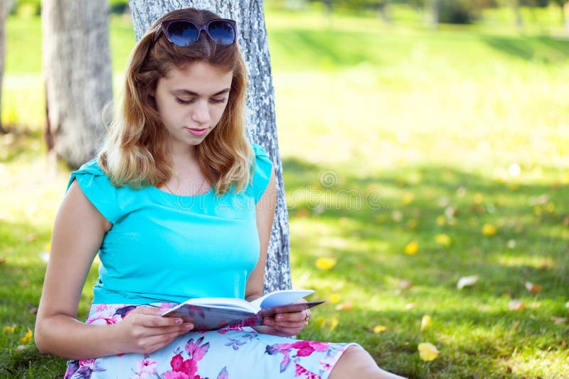 Teenage Girl Sitting On The Grass And Reading Book Stock Image Image