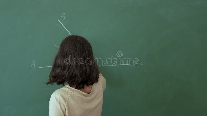 A Teenage Girl Solves a Math Problem on the Board during a Math Lesson ...