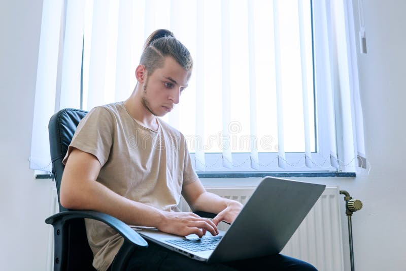 Teenage Guy Student Sitting at Home in Chair Using Laptop Stock Image ...