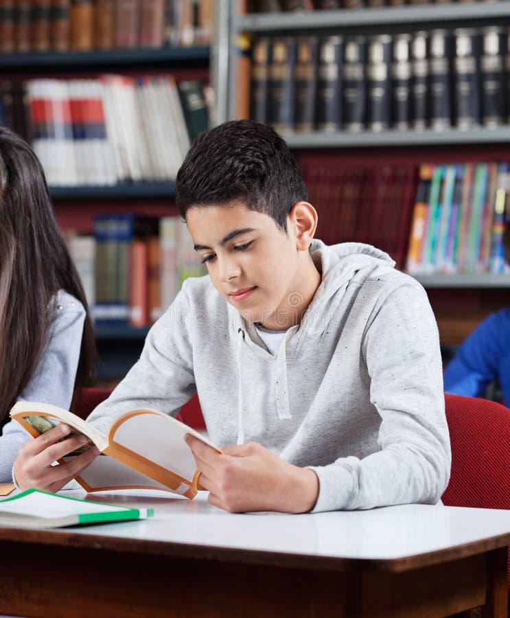 Teenage Schoolboy Reading Book in Library Stock Image - Image of indoor ...