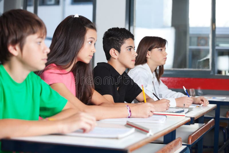 Teenage Students Looking Away while Studying at Stock Photo - Image of ...