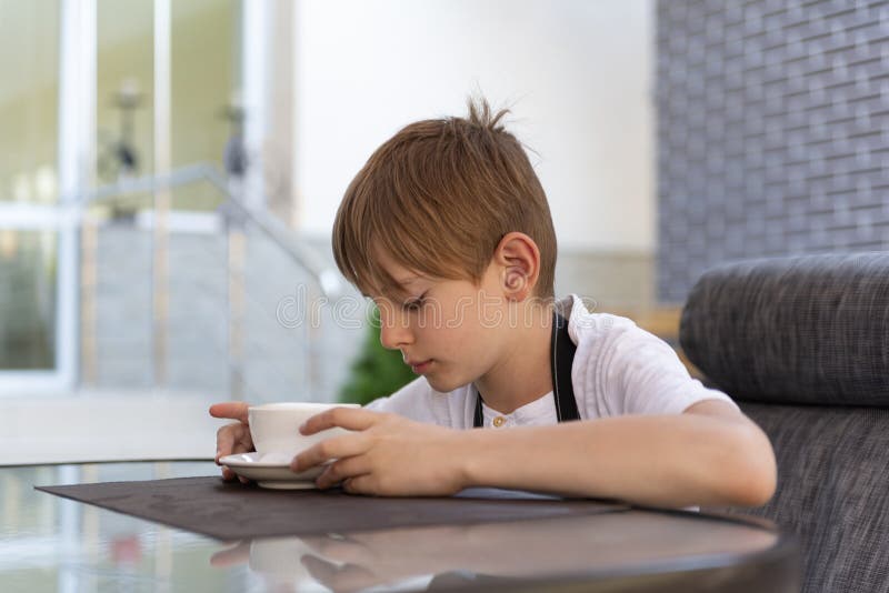 Teenager in Cafe Drinks Coffee. Boy Sitting in Cafe with Cup in His ...