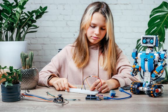 A Teenager Girl Plugging Cables To Sensor Chips While Learning Arduino Coding And Robotics Stock