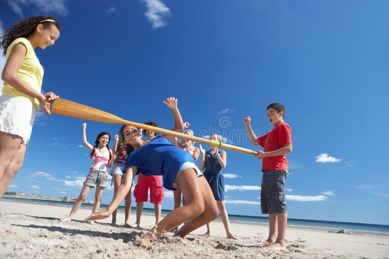 Teenagers Doing Limbo Dance on Beach Stock Photo - Image of clouds ...