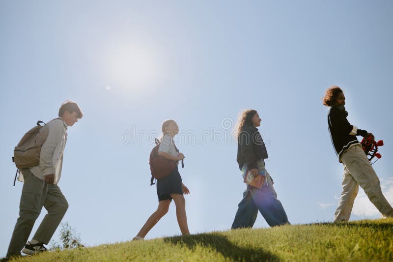 Teens Walking on Grass stock photo. Image of together - 342930302