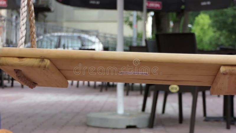 A Teeter-totter Swinging Back and Forth in a Patio with Chairs Stock ...