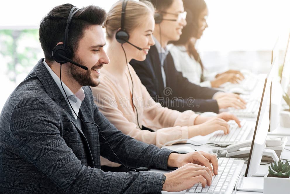 Telemarketing or Hotline Operators Working with Computers at Light ...