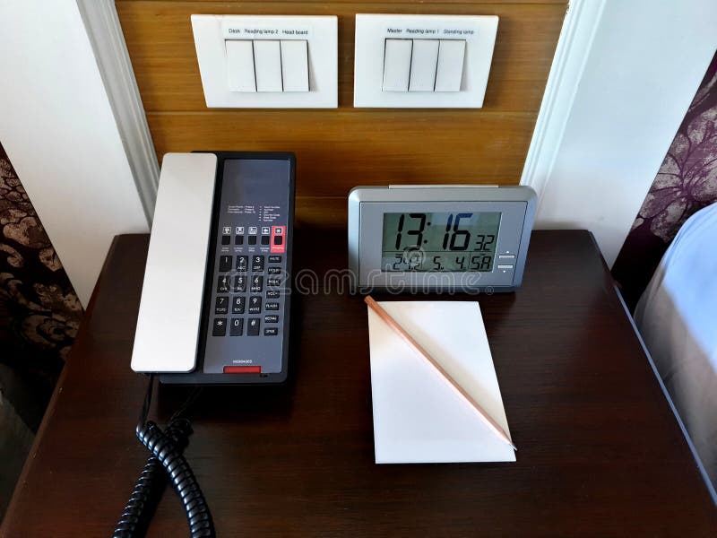 The Telephone, Digital Clock and Paper Note with Pencil on a Desk Stock ...