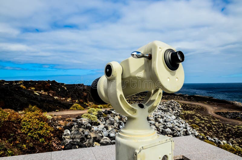 A Telescope is Mounted on a Pole in Front of a Rocky Shoreline Stock ...