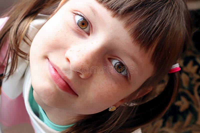 A Ten Year Old Girl With Brown Eyes Looks Up From The Bottom Close Up