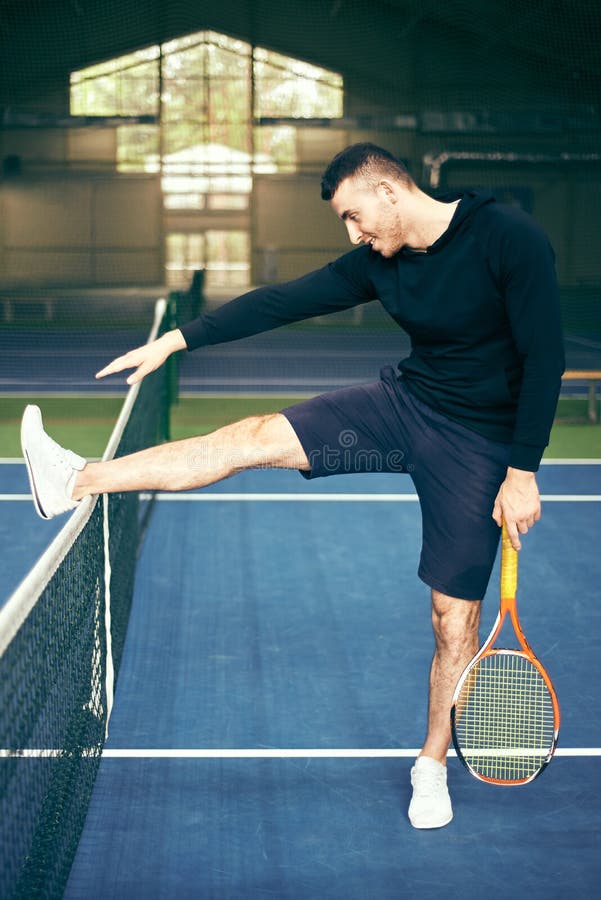Tennis Player is Warming Up on the Tennis Court. Athletic Young Guy ...