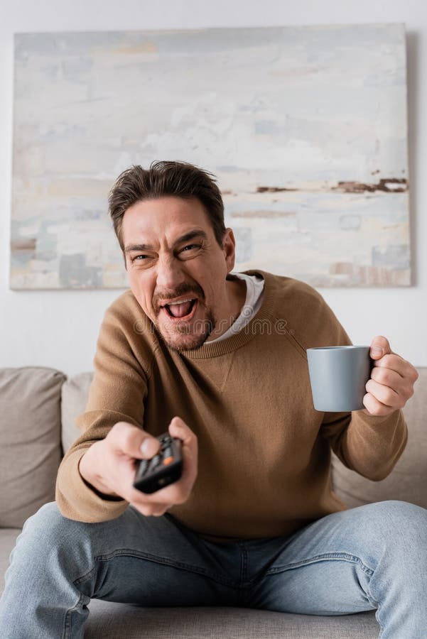 Tensed Man Holding Remote Controller and Stock Photo - Image of jumper ...