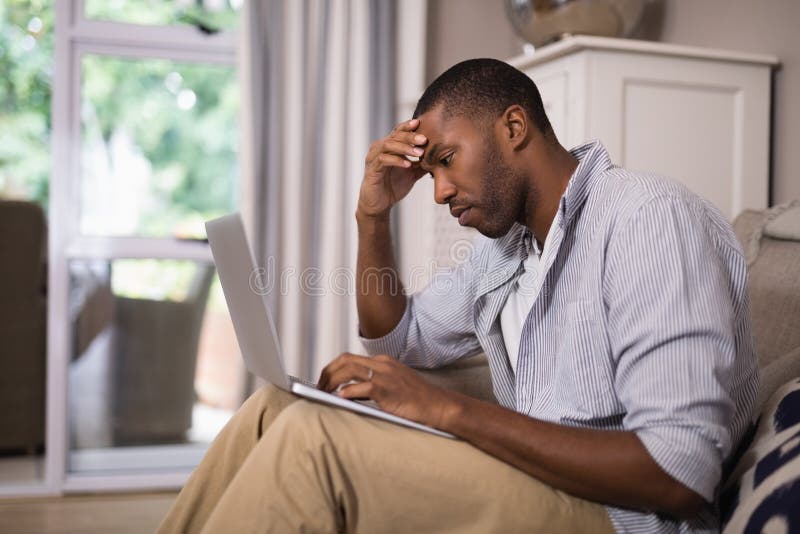 Tensed Man Using Laptop while Sitting at Home Stock Photo - Image of ...