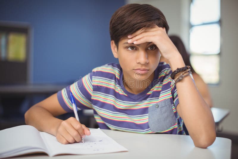 Tensed School Boy Doing Homework in Classroom Stock Image - Image of ...