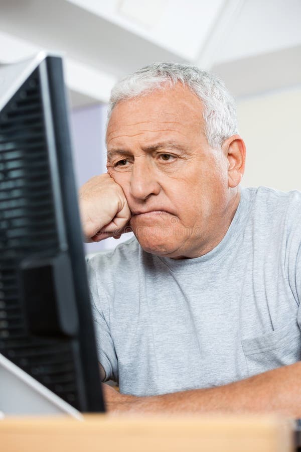 Tensed Senior Man Looking at Computer in Class Stock Photo - Image of ...