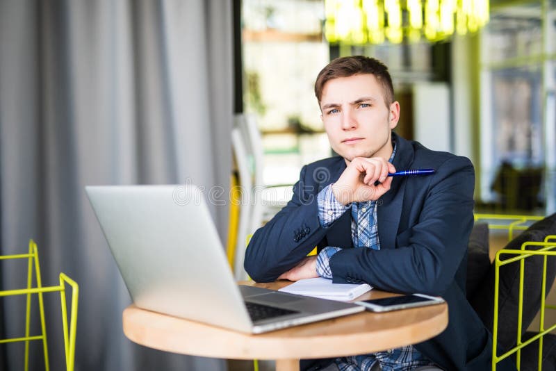 Tensed Young Man Working on Laptop at Cafe Table and Thinking Stock ...