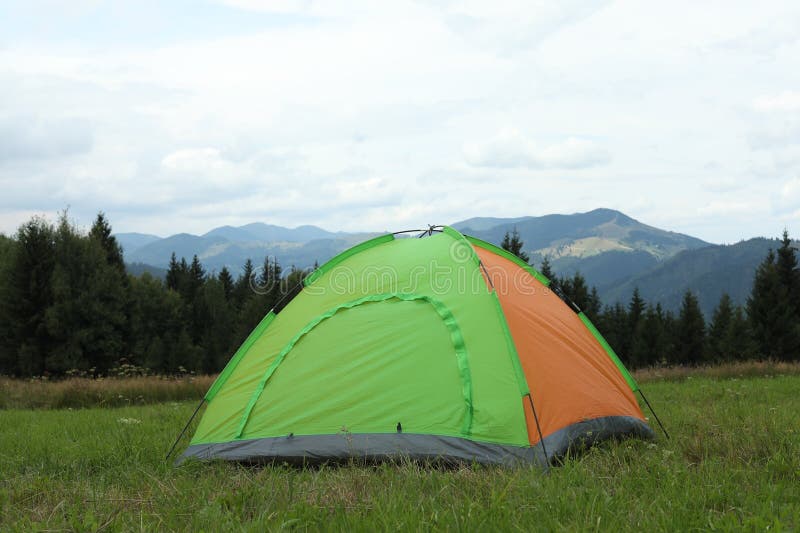 Tent on Green Grass in Mountains. Camping Equipment Stock Image - Image ...