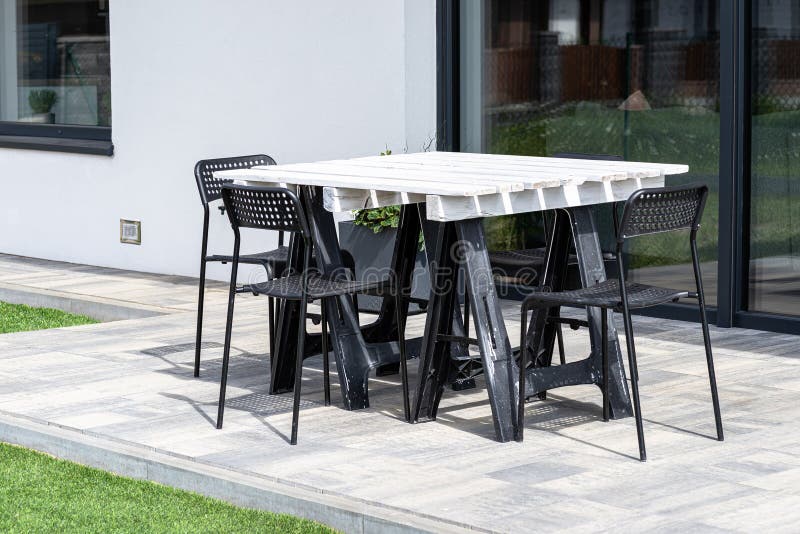 Terrace Table Made of White Pallet Standing on Plastic Trestles, Black ...