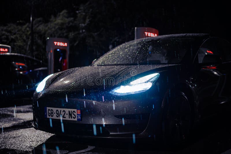 Tesla Car Charging at Supercharger at Night Under the Rain Editorial ...