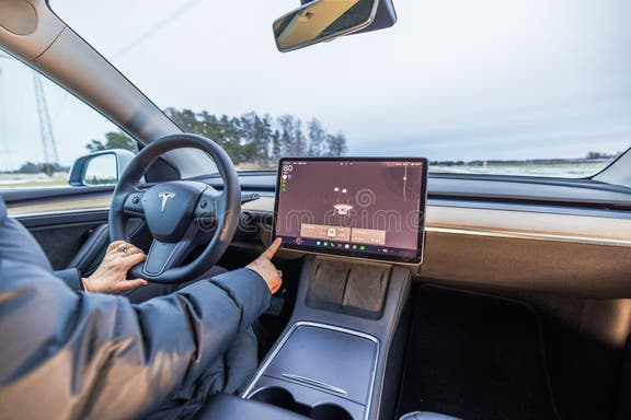 Tesla Model Y Driver Interacting with Touchscreen Display, Showcasing ...