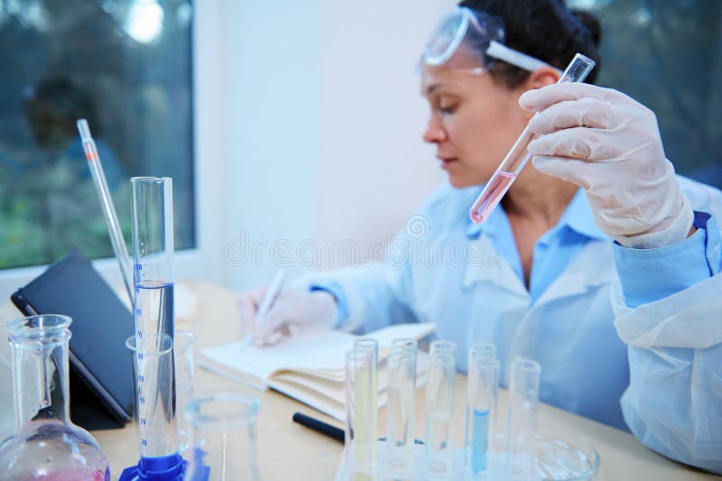 Test Tube with Solution, in the Hand of Scientist, Writing Down Results ...
