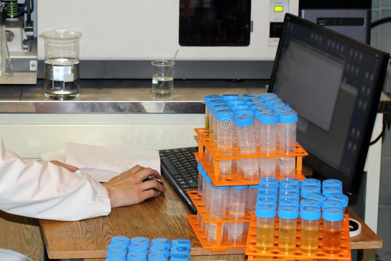 Engineer Ecologist Analyzes the Computer. Test Tubes with Samples of ...