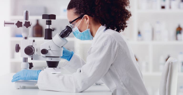 Testing Some New Samples. a Young Scientist Using a Microscope in a Lab ...
