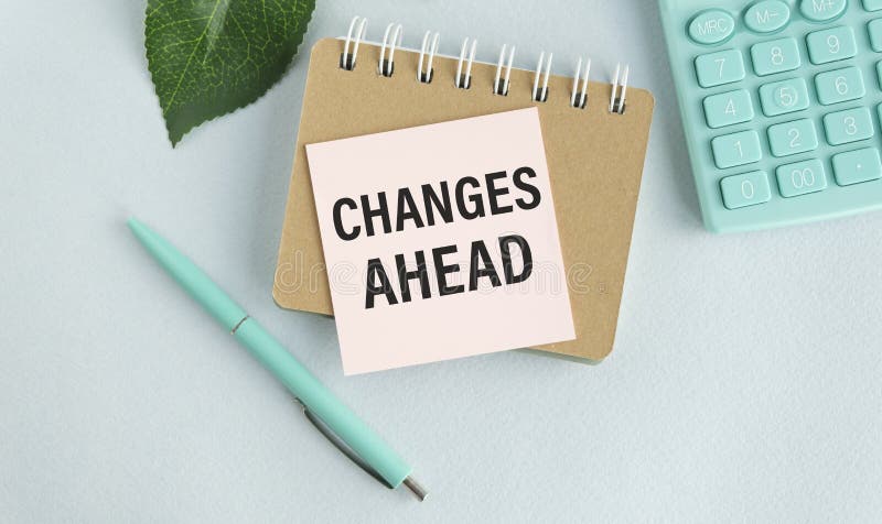 Text Changes Ahead on White Paper Sheet and Brown Paper Notepad on the ...