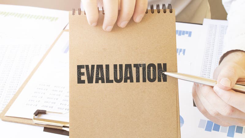 Text EVALUATION on Brown Paper Notepad in Businessman Hands on the ...