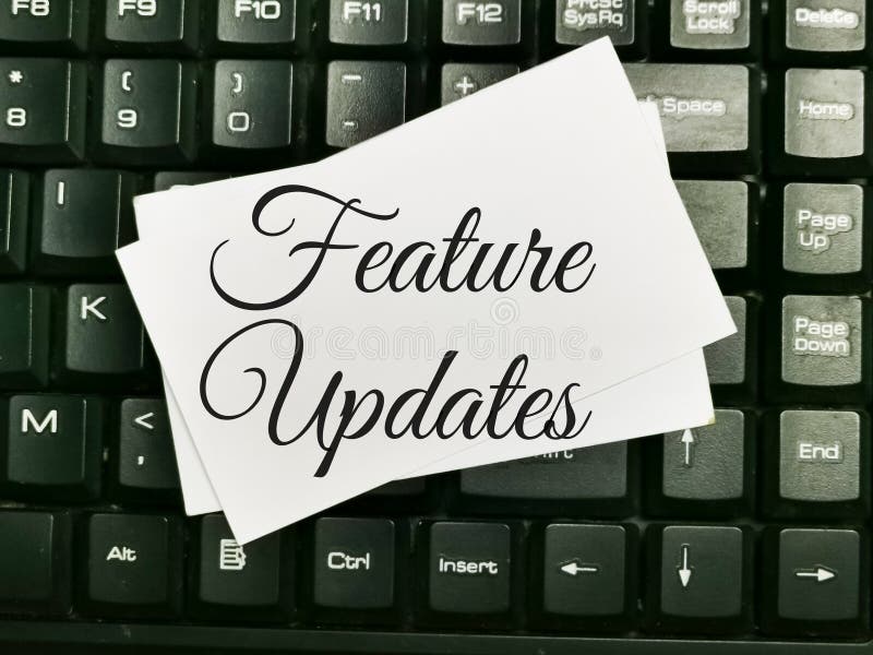 Text FEATURE UPDATES Written on White Paper Note on Computer Keyboard ...