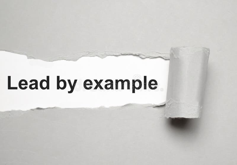 The Text Lead by Example Appearing Behind Torn Grey Paper Stock Photo ...