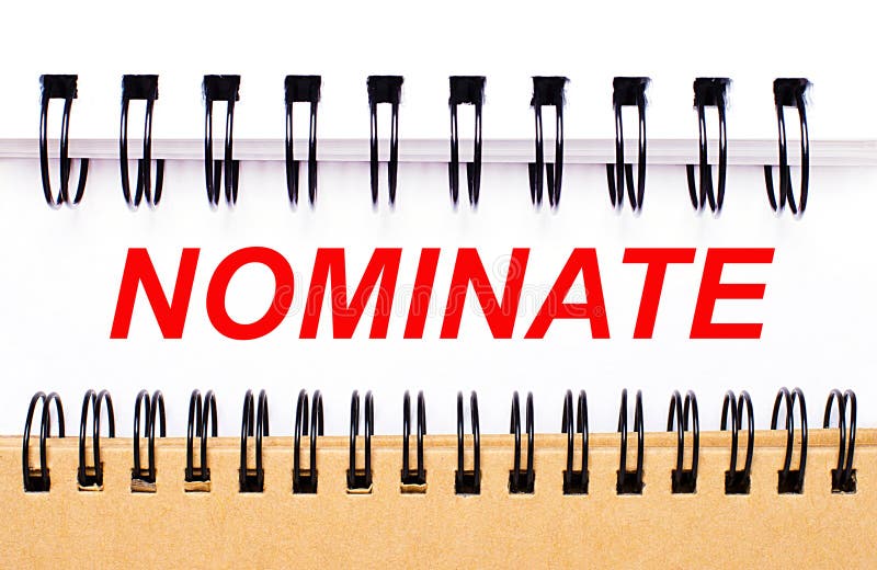 Text NOMINATE on White Paper between White and Brown Spiral Notepads ...