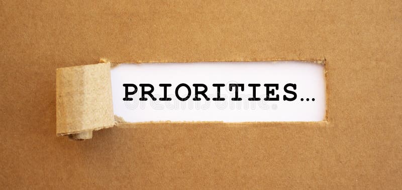 Text PRIORITIES Appearing Behind Torn Brown Paper. Top View Stock Image ...