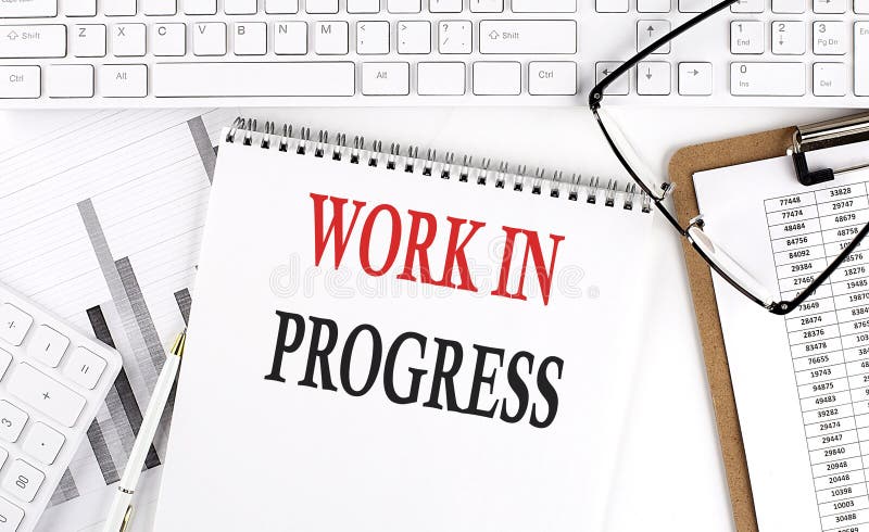 Text WORK in PROGRESS on Office Desk Table with Keyboard, Notepad and ...